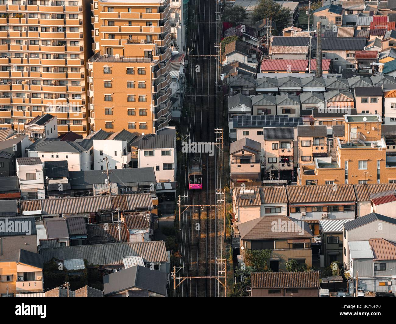 Aerial view of Osaka tram on straight tracks through compact housing ...