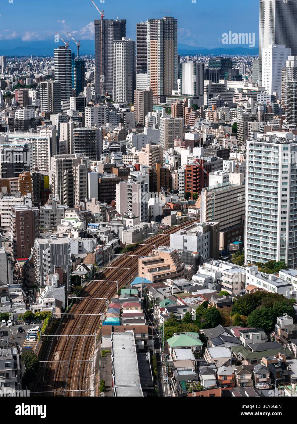 Aerial view of JR tracks curving through Tokyo toward tower clusters ...