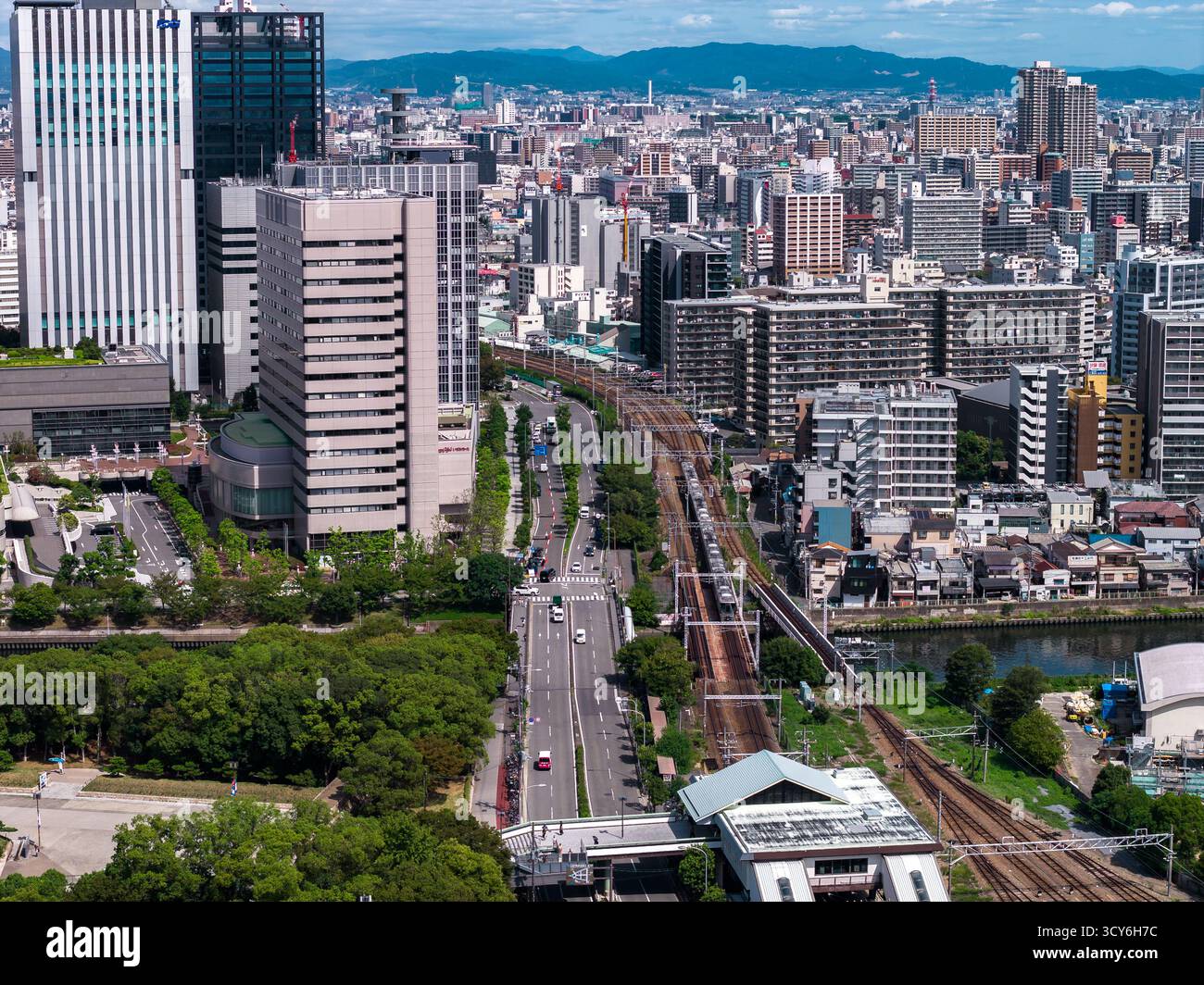 Aerial daytime view of Osaka urban skyline with rail and river corridor ...