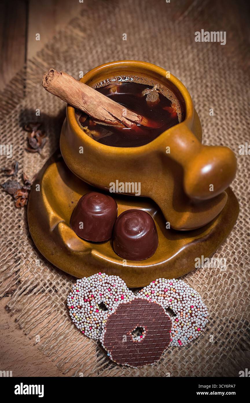 Rustic ceramic cup with hot drink and cinnamon stick, surrounded by ...