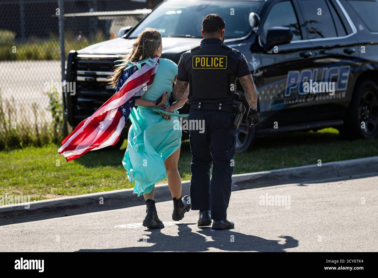 A Broadview police officer detains an activist dressed like the Statue ...