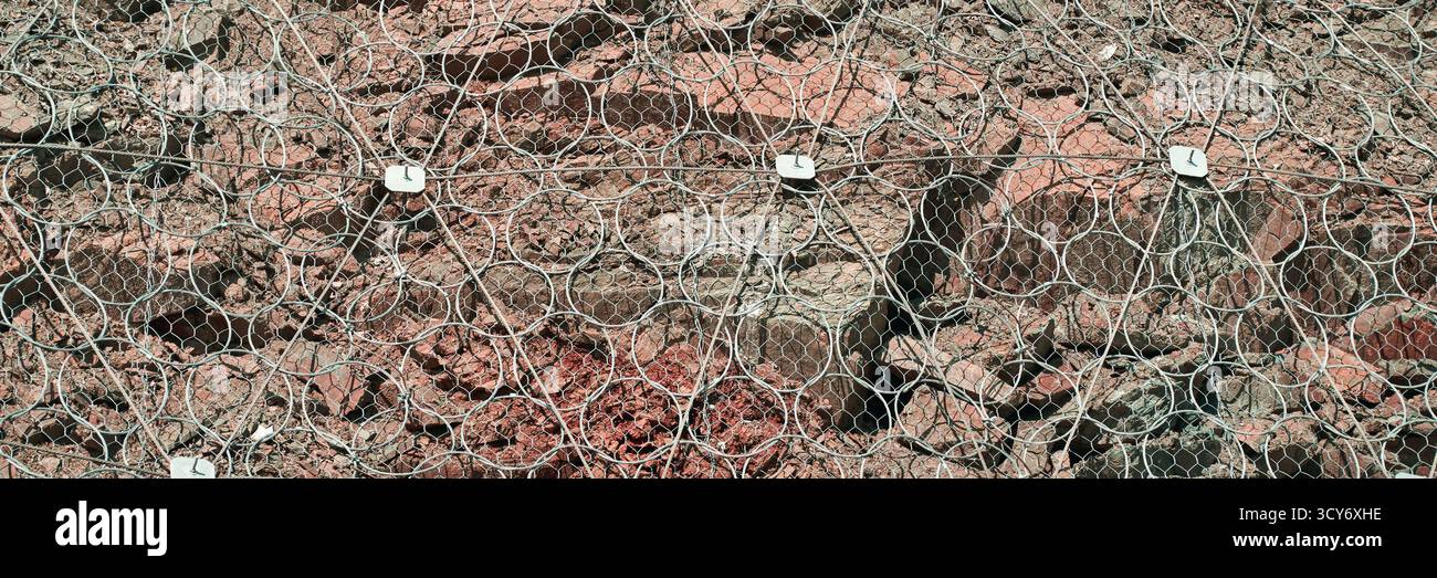 Rock slope reinforcement with wire mesh grid for erosion control and ...