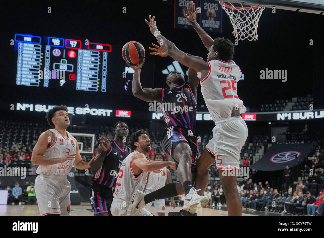 Yakuba Ouattara of Paris goes for a layup by Hapoel's Dan Oturu during ...