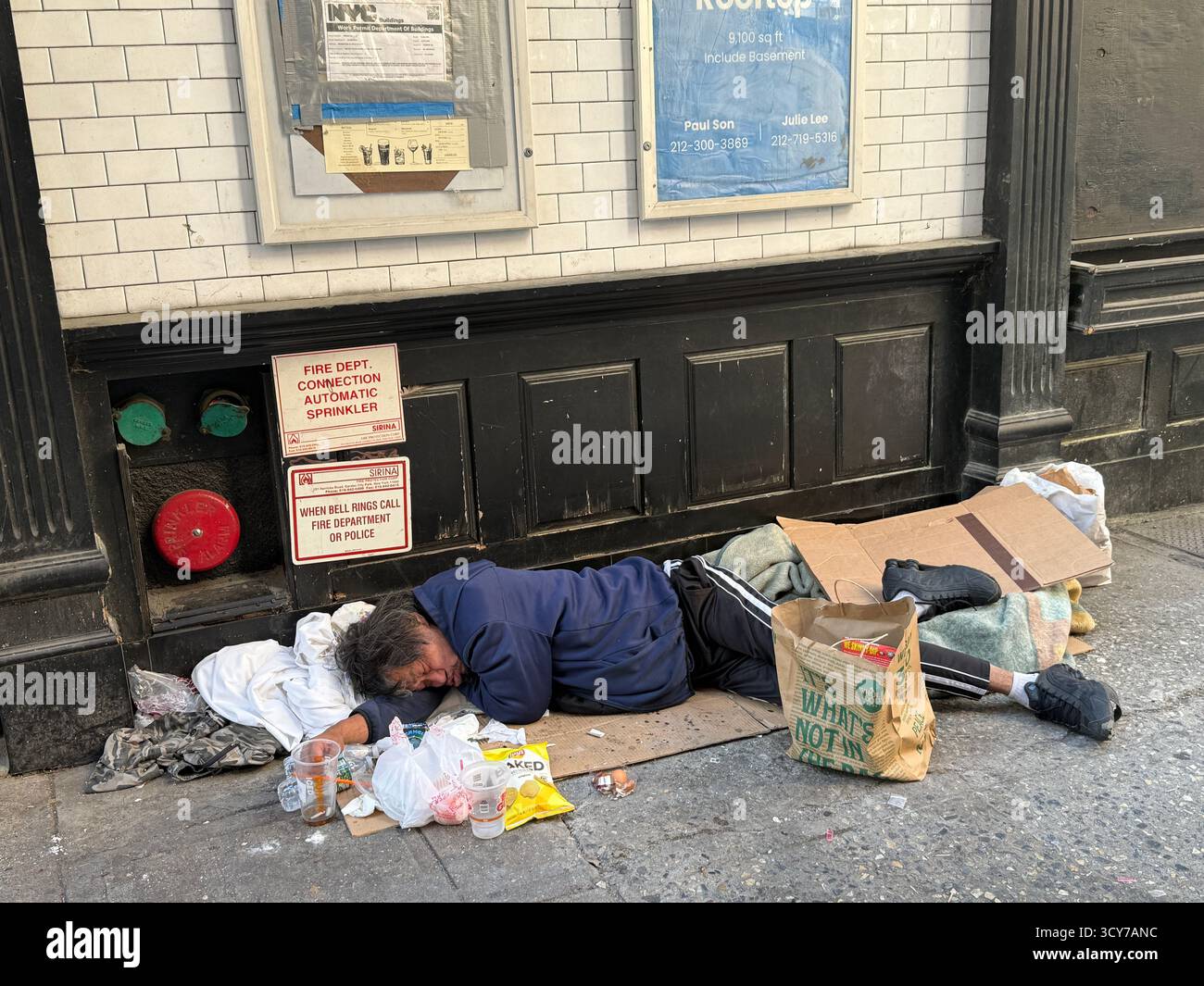 Homeless man sprawled out on the sidewalk in midtown Manhattan, New ...