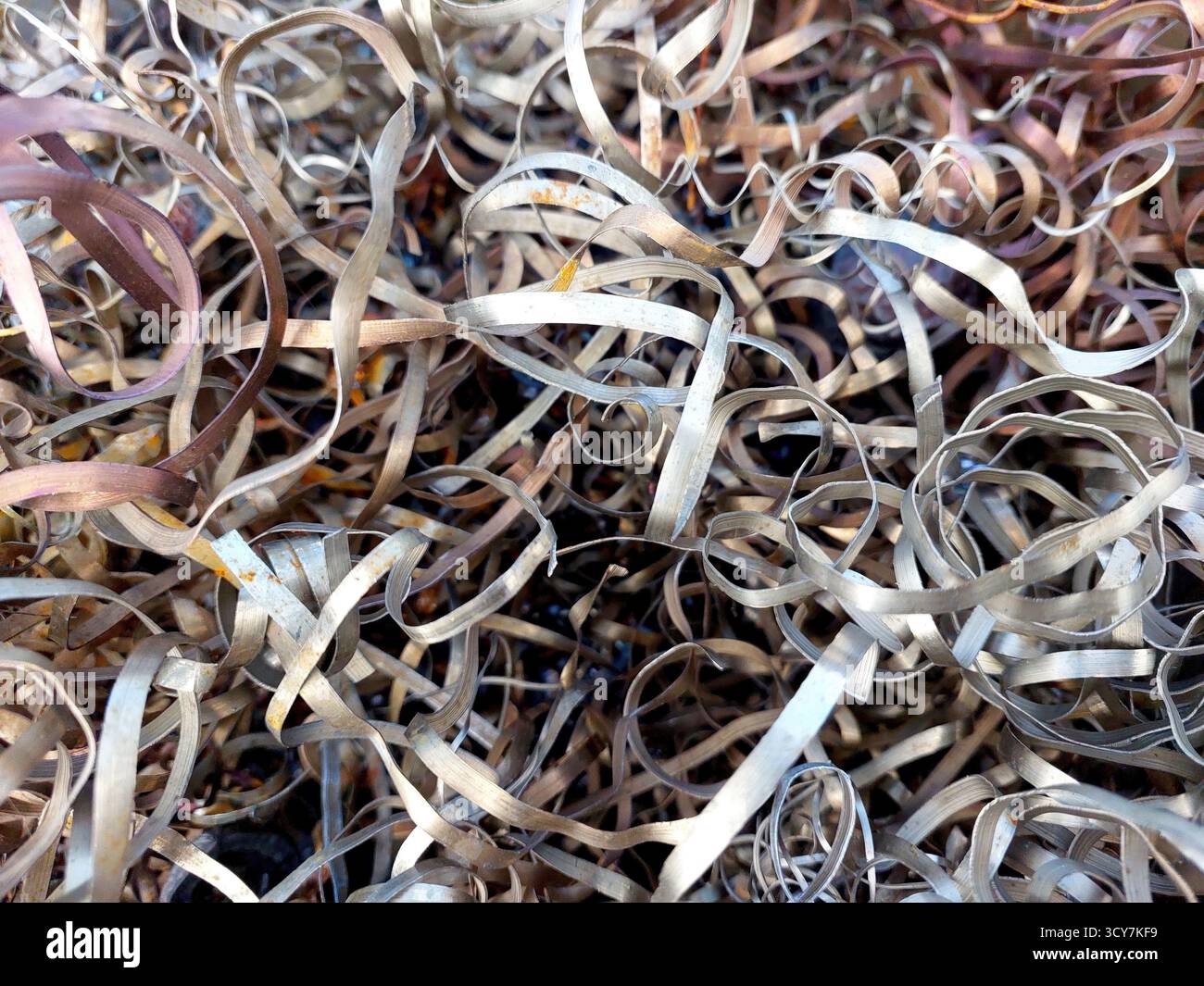 Steel shavings lie on the workshop floor, remnants from a metal turning ...
