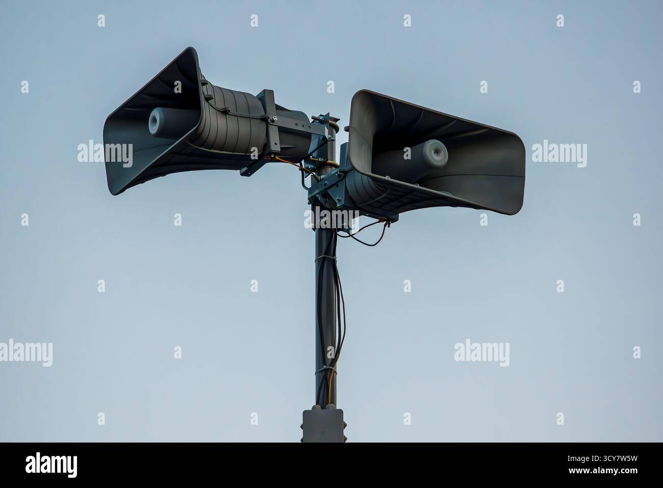 Modern air raid warning loudspeaker mounted on a metal pole, used for ...