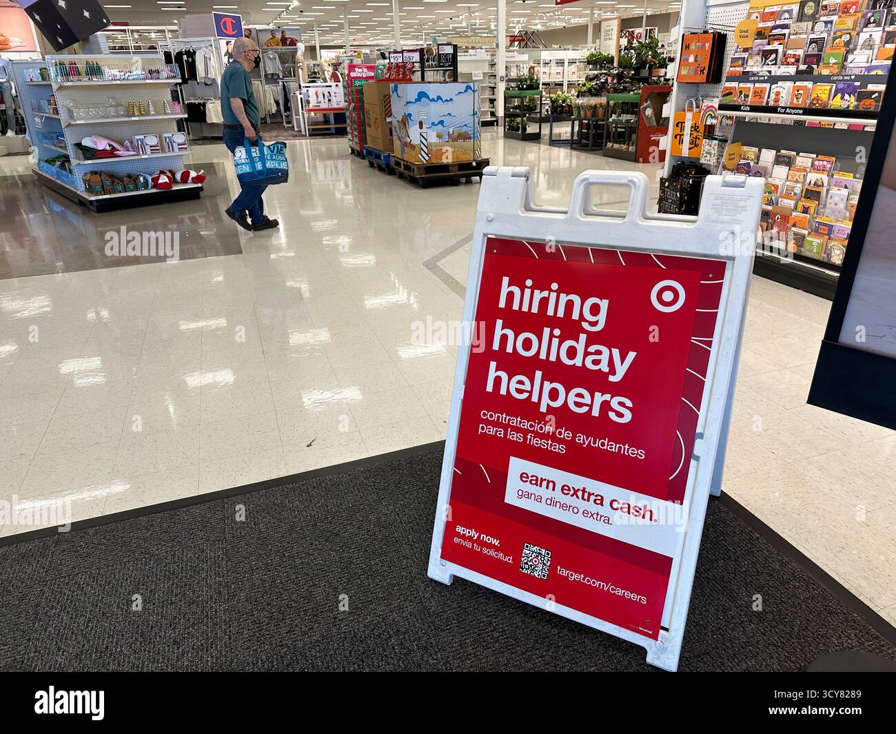 A shopper passes by a holiday hiring sign in the entryway of a Target ...