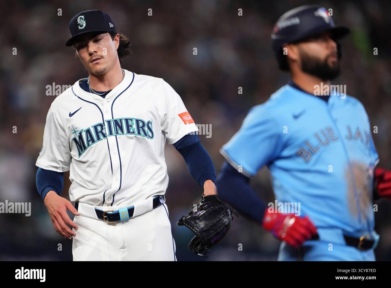 Seattle Mariners pitcher Bryan Woo, left, reacts after giving up a run ...