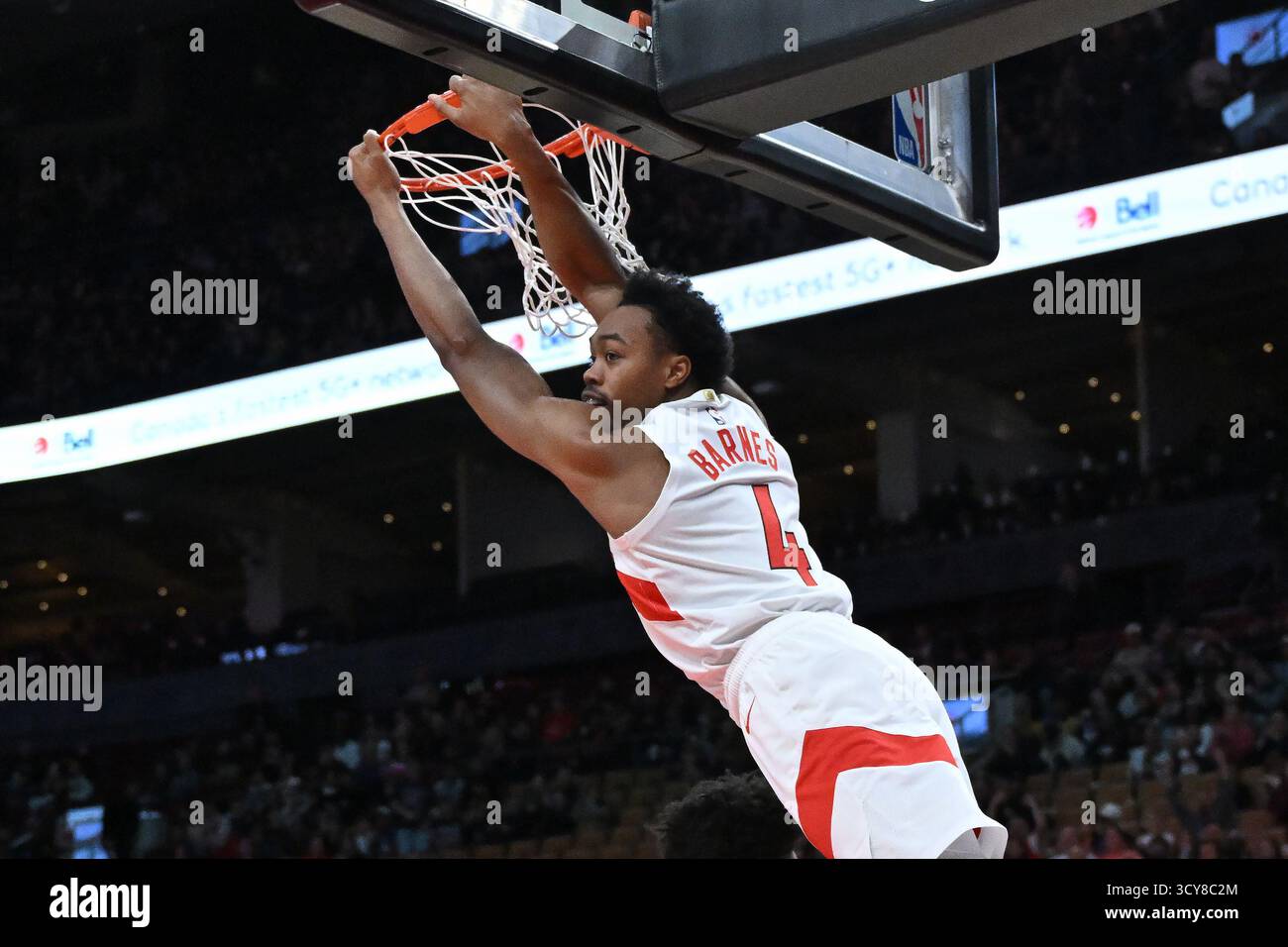 Toronto Raptors' Scottie Barnes hangs from the rim after dunking ...