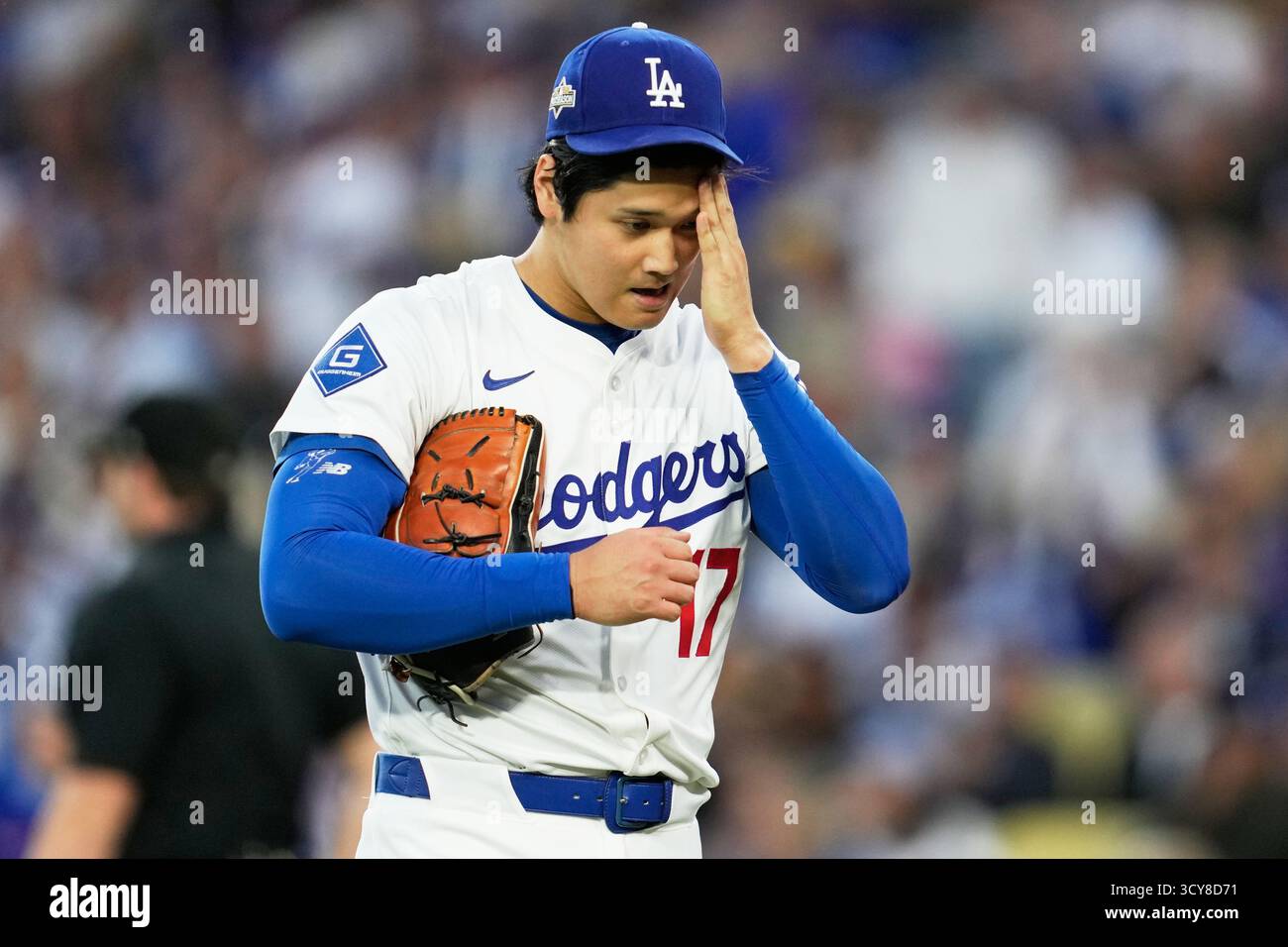 Los Angeles Dodgers pitcher Shohei Ohtani wipes his face during the ...