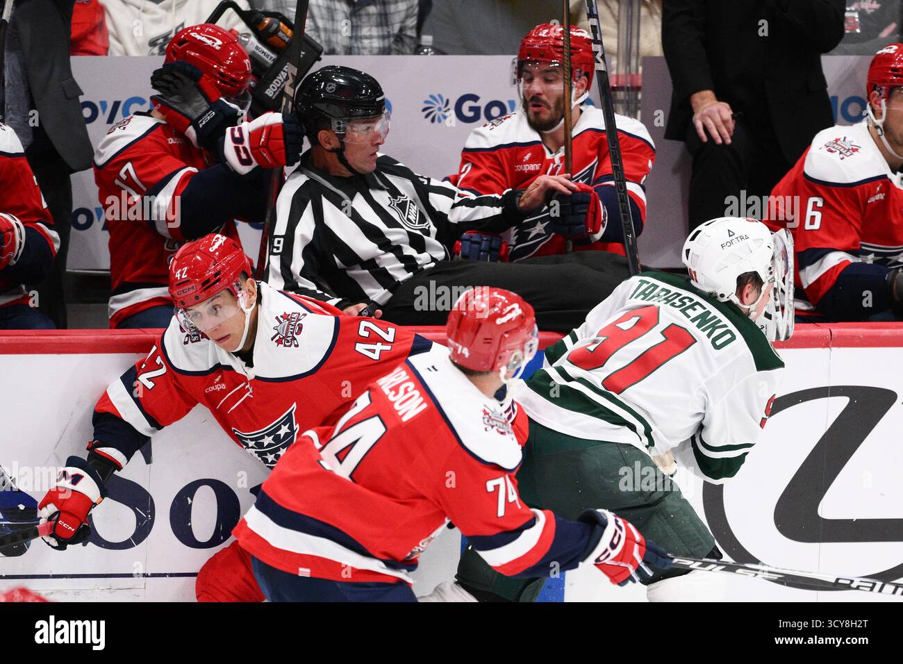 NHL linesperson Steve Barton, center, falls in the Washington Capitals ...