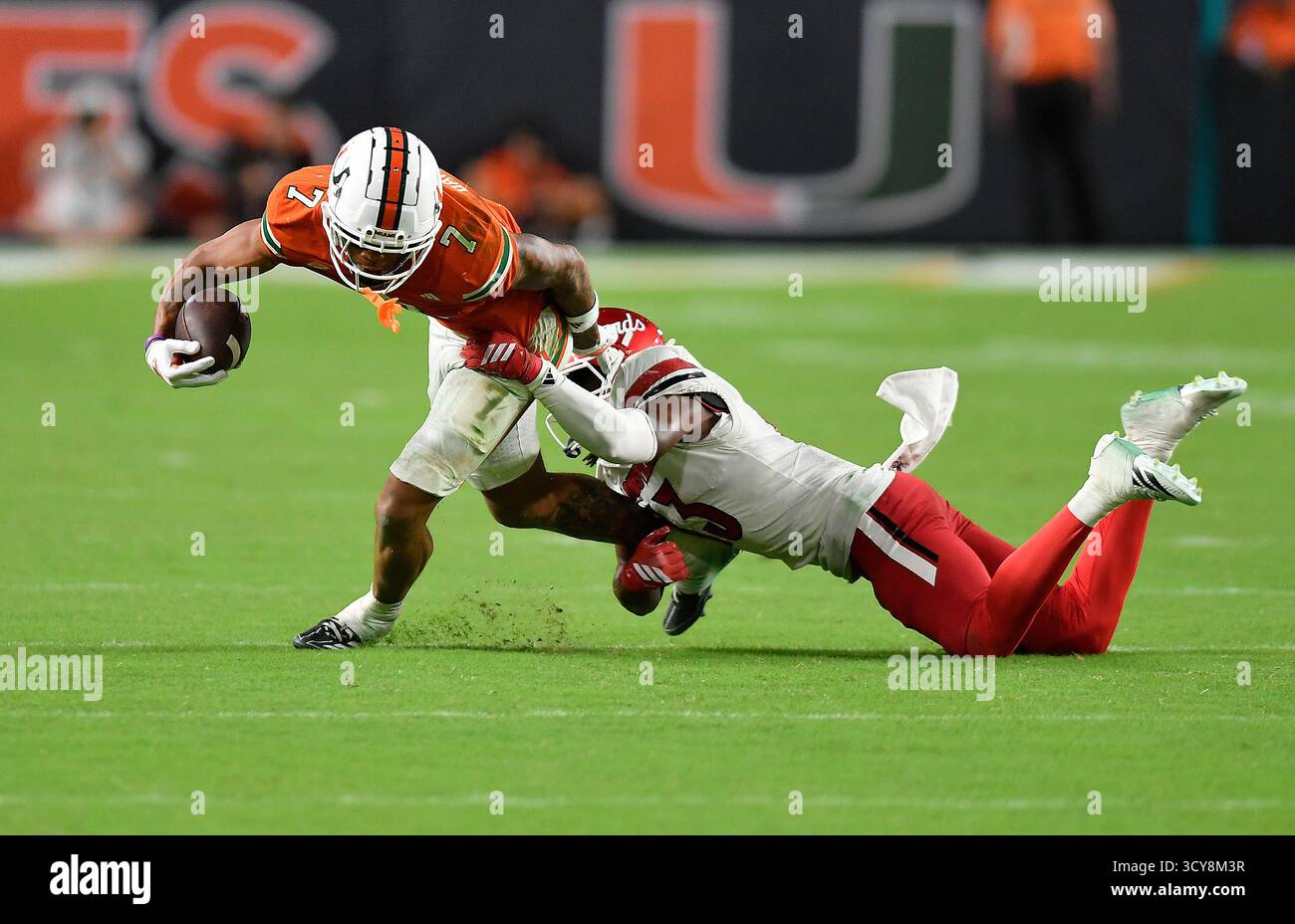 Miami wide receiver CJ Daniels (7) is tackled by Louisville cornerback Justin Agu during the ...