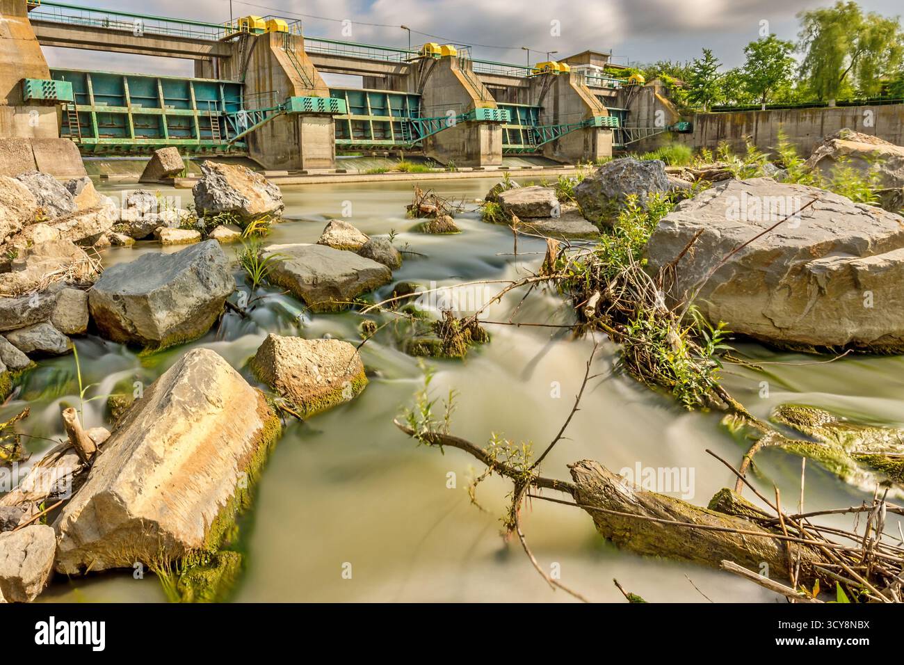 Romanian dam with sluice gates and smooth water flow. Rocks and ...