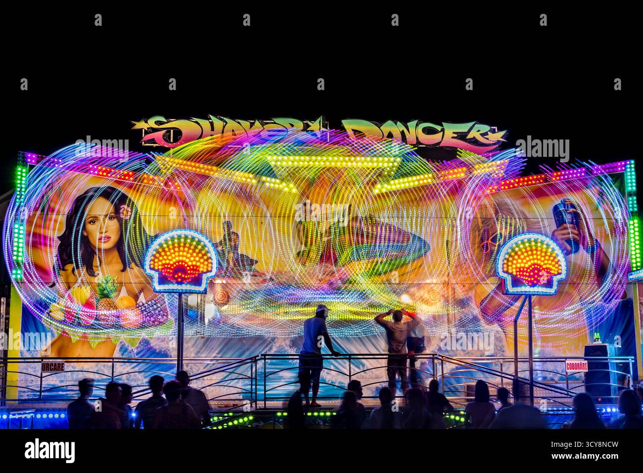 Colorful Shake Dancer ride in Romanian fairground. Motion blur and neon ...