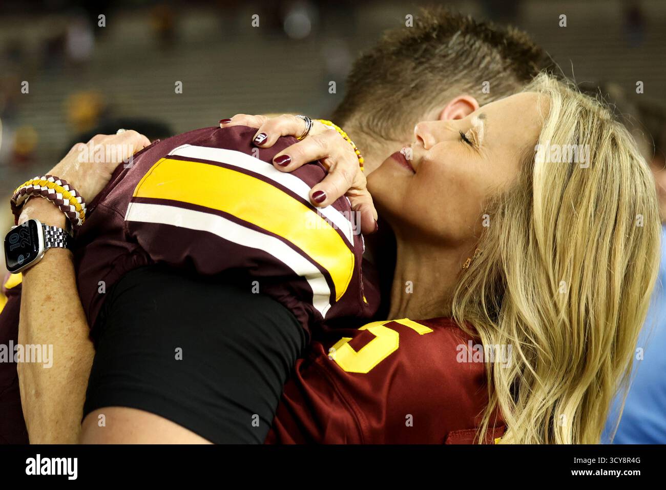 Minnesota quarterback Drake Lindsey (5) hugs his mother Amy Lindsey ...