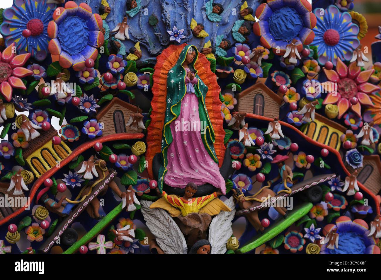 A statue of the Virgin of Guadalupe decorates a tree of life sculpture ...