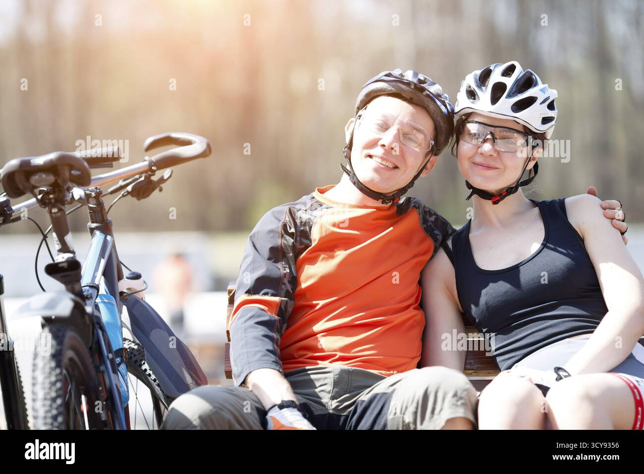 Photo of bicyclists on bench in park Stock Photo - Alamy