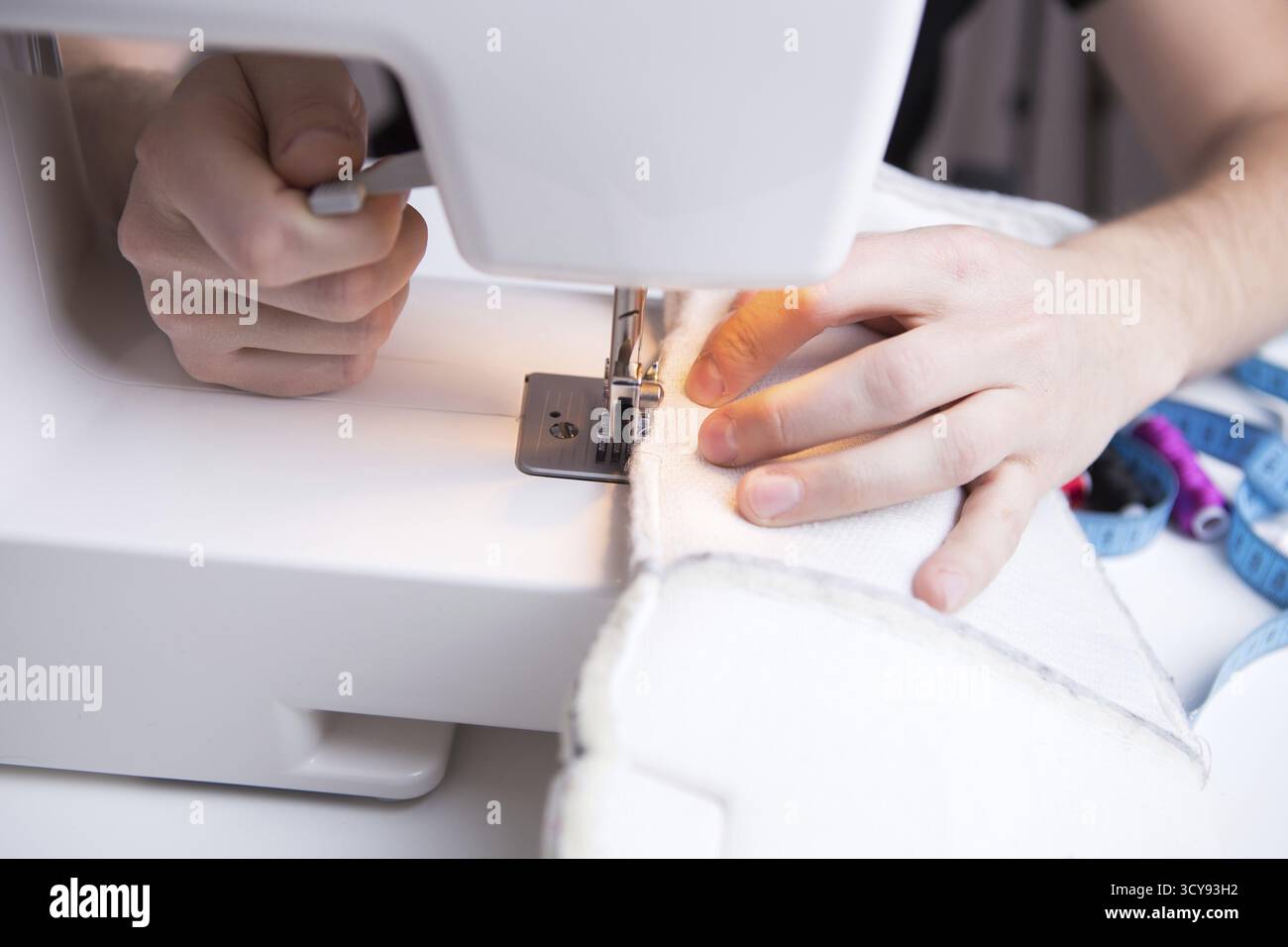 Girl stitching white cloth on sewing machine Stock Photo - Alamy