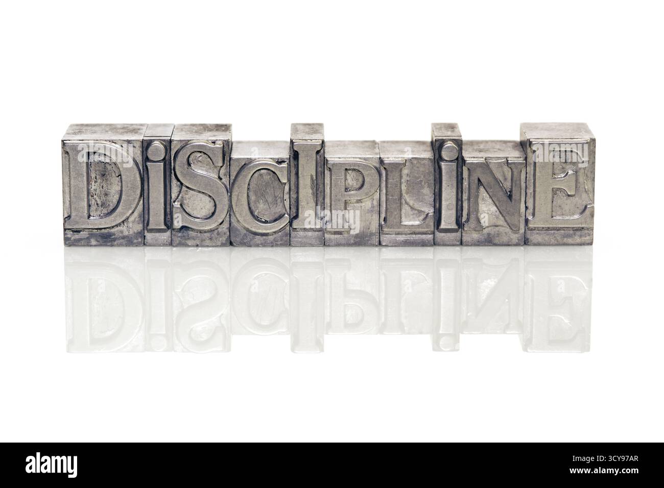 Discipline word made from metallic letterpress type on reflective ...