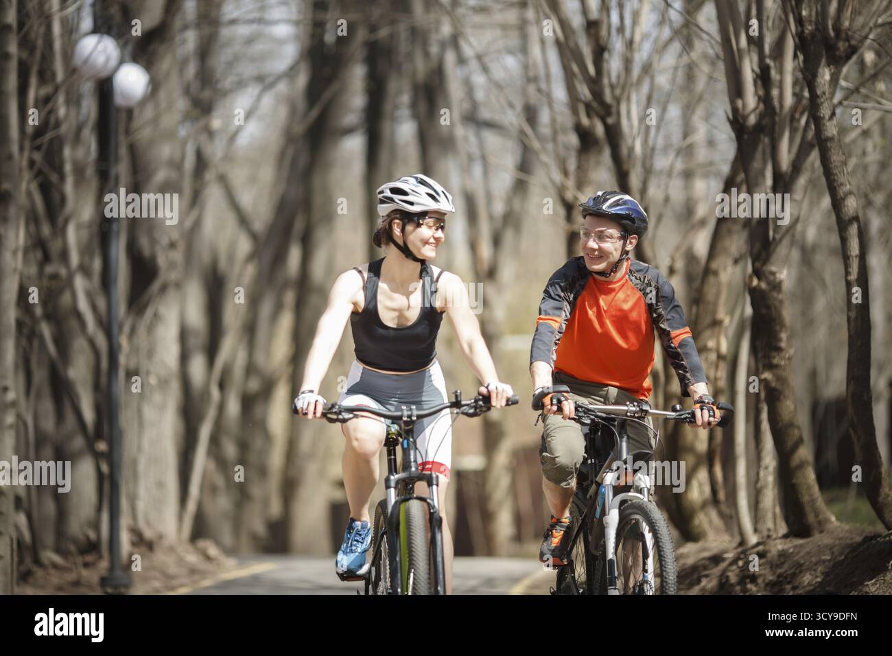 Two bicyclists drive around park in afternoon Stock Photo - Alamy