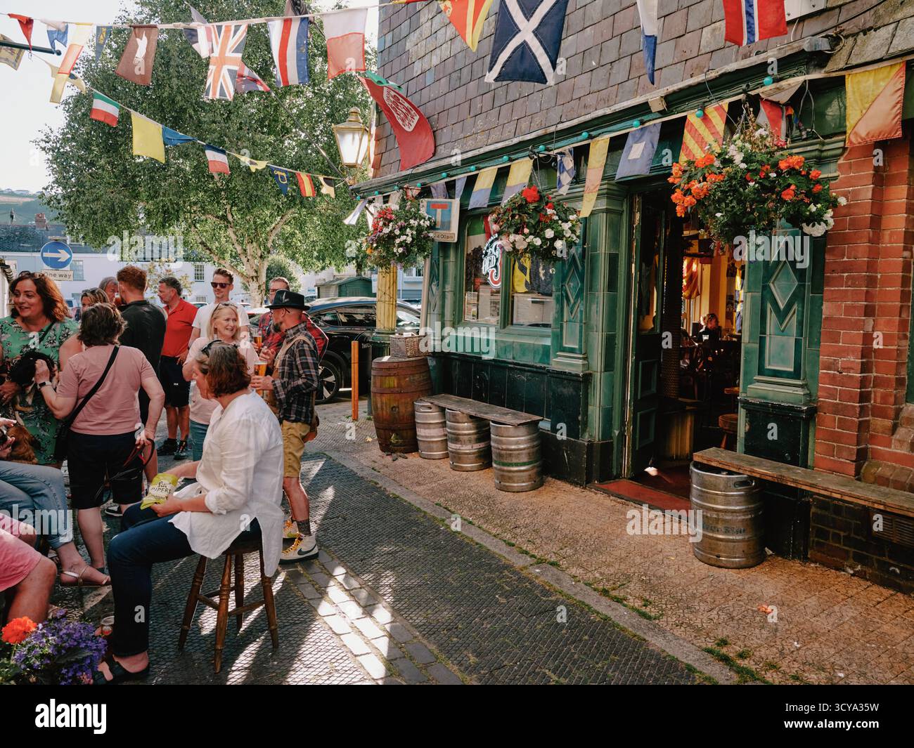 People enjoying a summer evening at a pub in Dartmouth Devon England UK ...