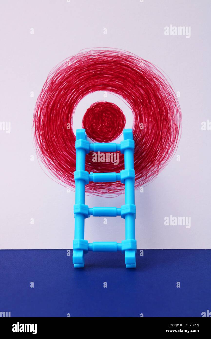 Ladder reaching the center of a target Stock Photo - Alamy
