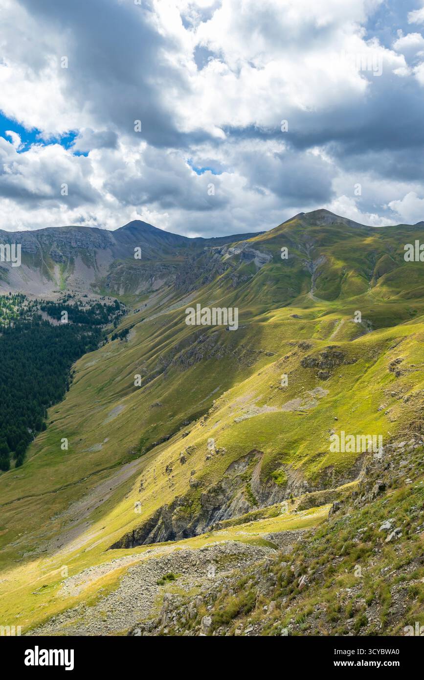 Verdant mountain slopes and a deep valley under a dramatic sky in ...