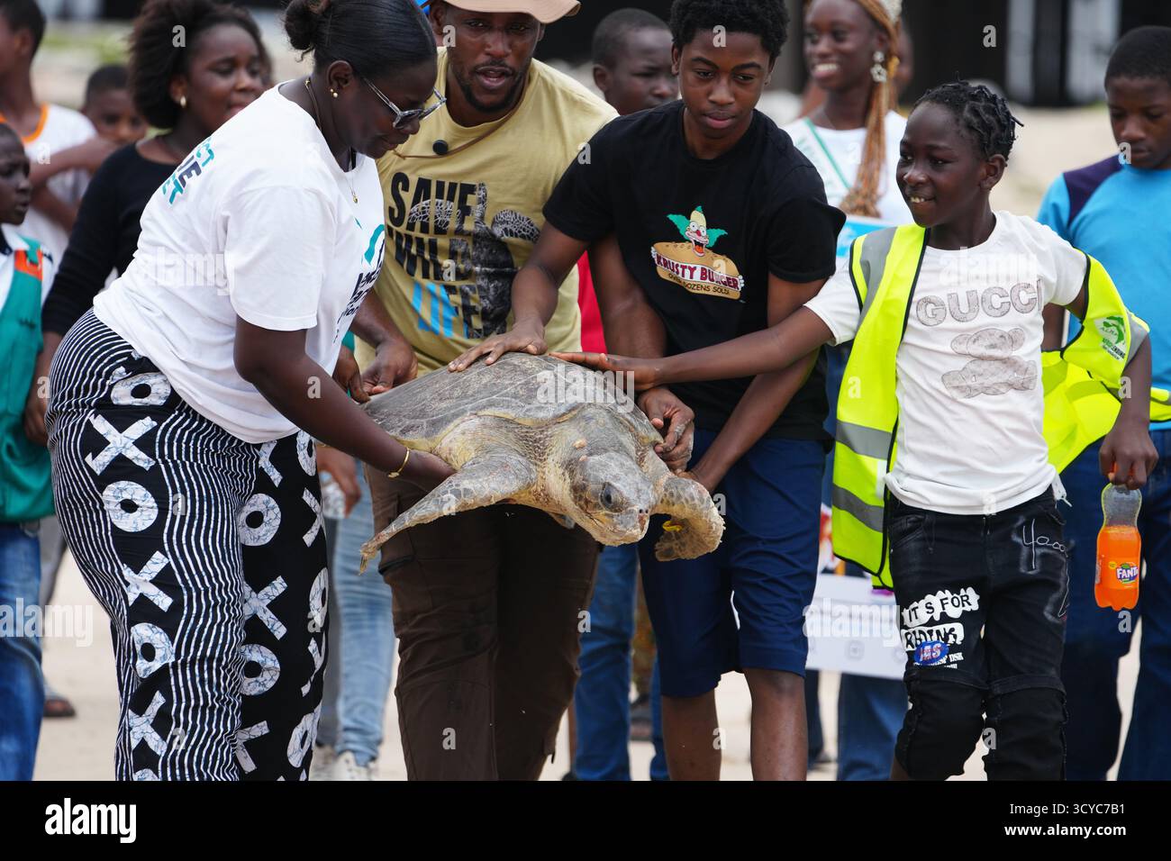 People play with an Olive Ridley sea turtle that was rescued from ...
