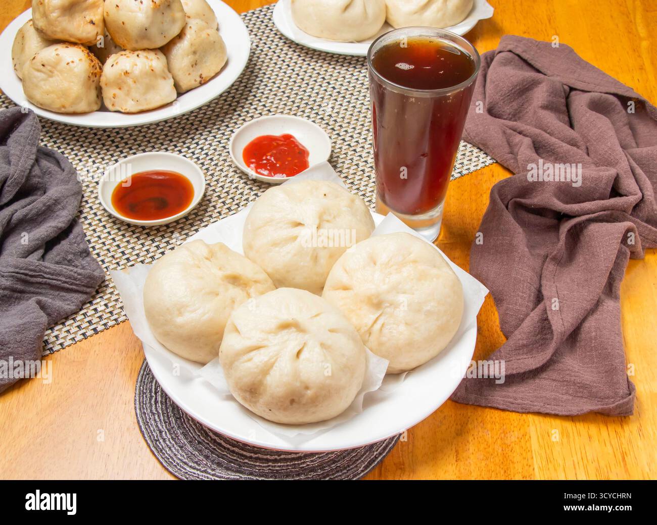 4 steamed pepper meat buns with Dipping Sauces and a tall glass of iced ...