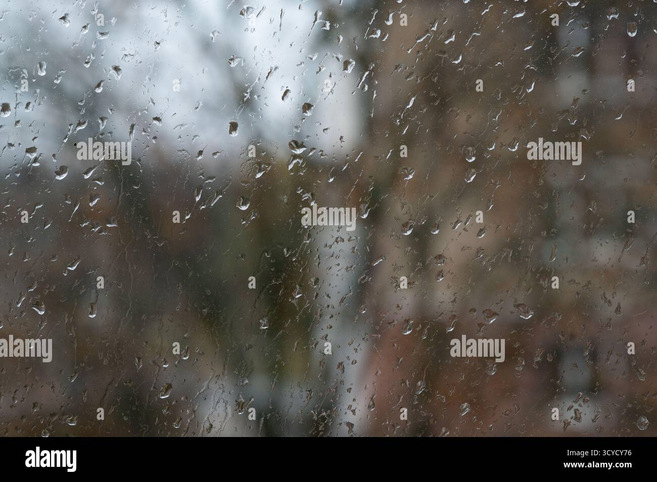 wet glass window, abstract backdrop. Water droplets merging into ...