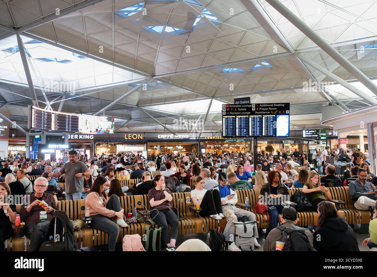 Wartehalle im Flughafen London Stansted. Reisende warten auf ihren ...