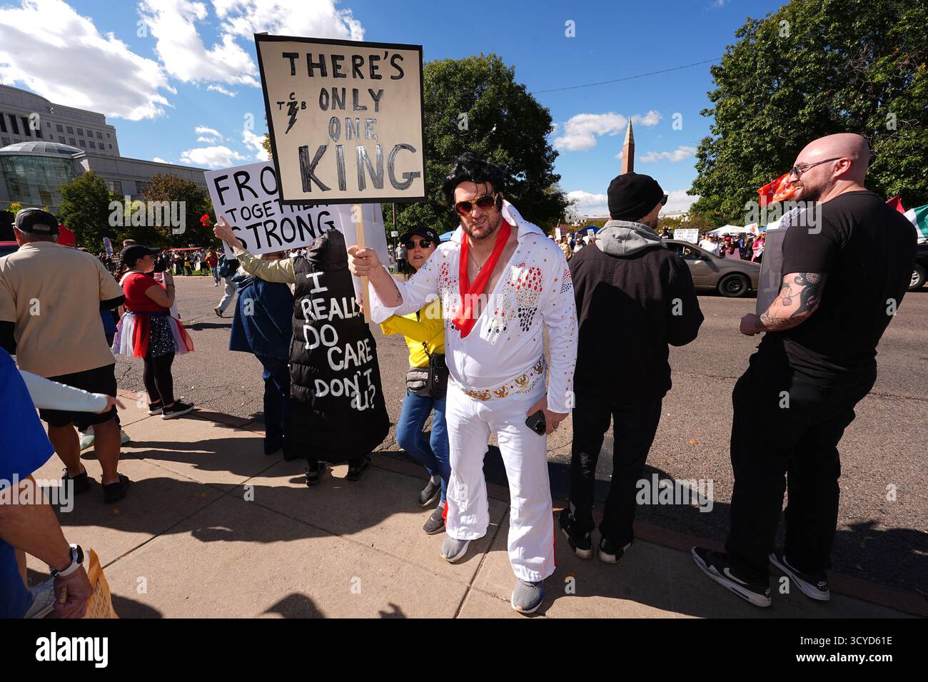 A rallygoer in a costume portraying singer Elvis Presley waves a ...