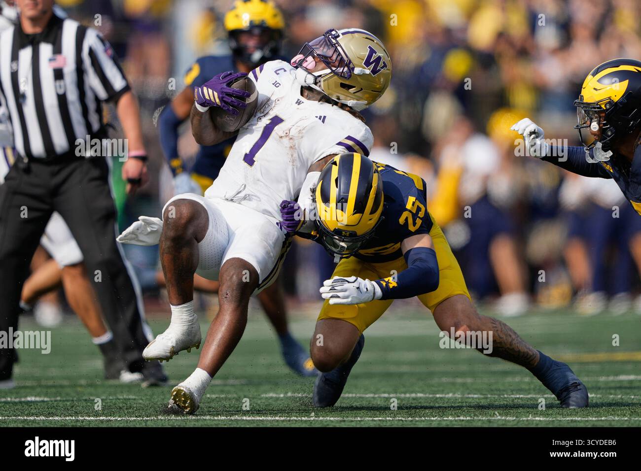 Washington running back Jonah Coleman, left, is tackled by Michigan defensive back Mason Curtis ...