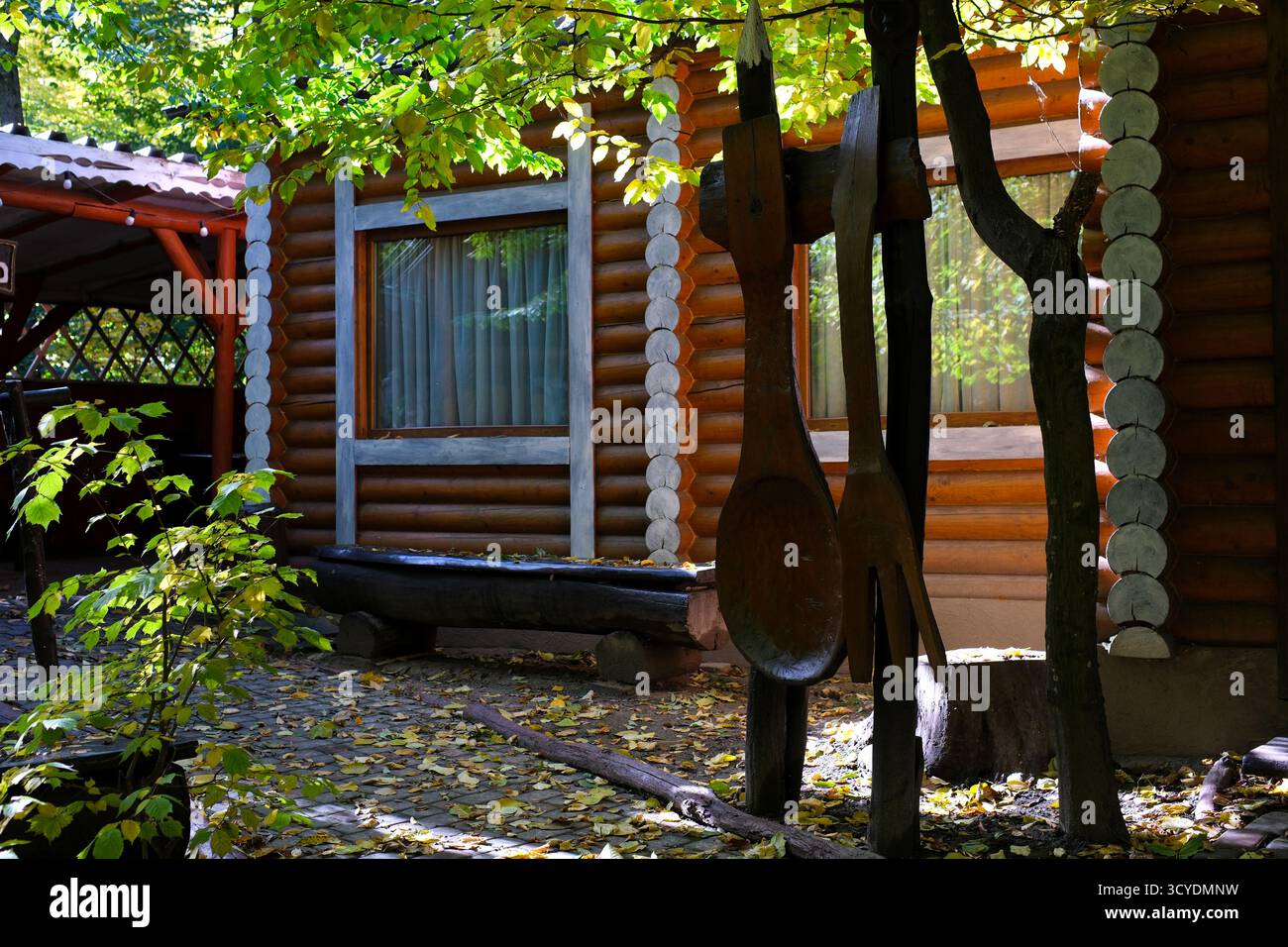 A modern cabin with a black corrugated metal wall and a wooden balcony ...