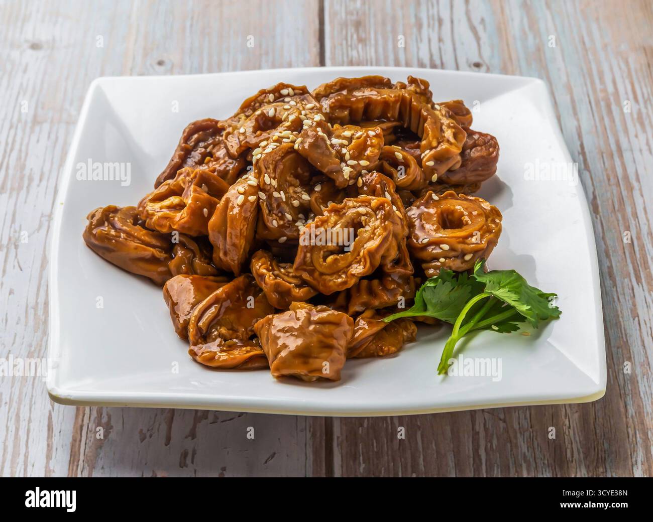 Braised Pork Intestines with a rich sauce, sprinkled with sesame seeds ...