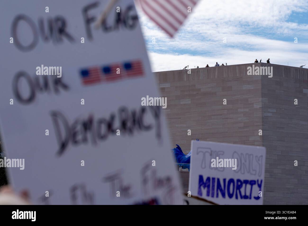 Counter snipers conduct overwatch as demonstrators carry signs during a ...