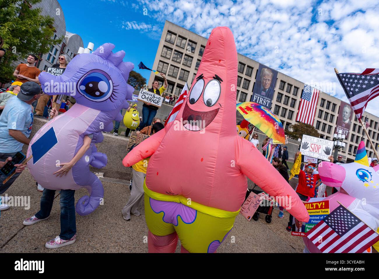 Demonstrators wear inflatable costumes and carry signs during a No ...