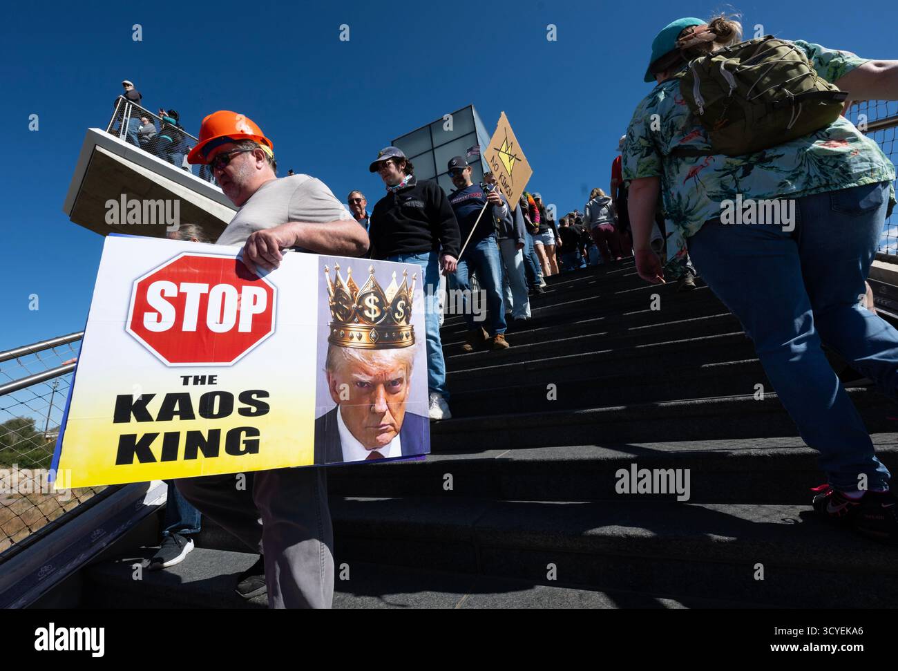 Protesters cross the pedestrian bridge into America the Beautiful Park ...