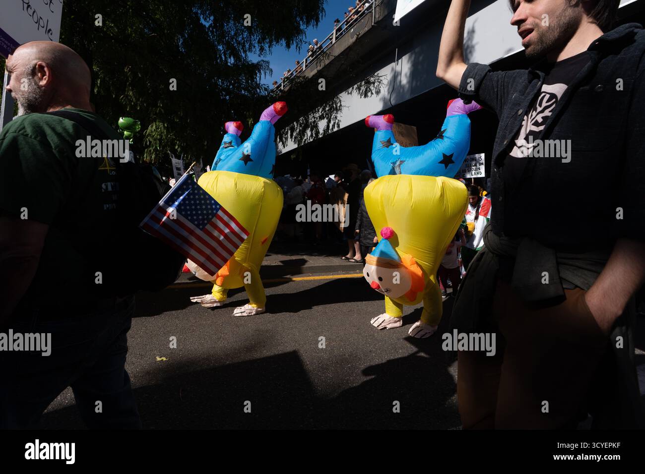 People in clown costumes participate in a "No Kings" protest march in ...