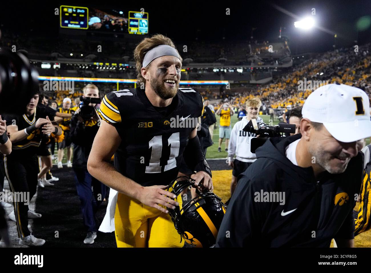 Iowa quarterback Mark Gronowski run off the field after an NCAA college ...