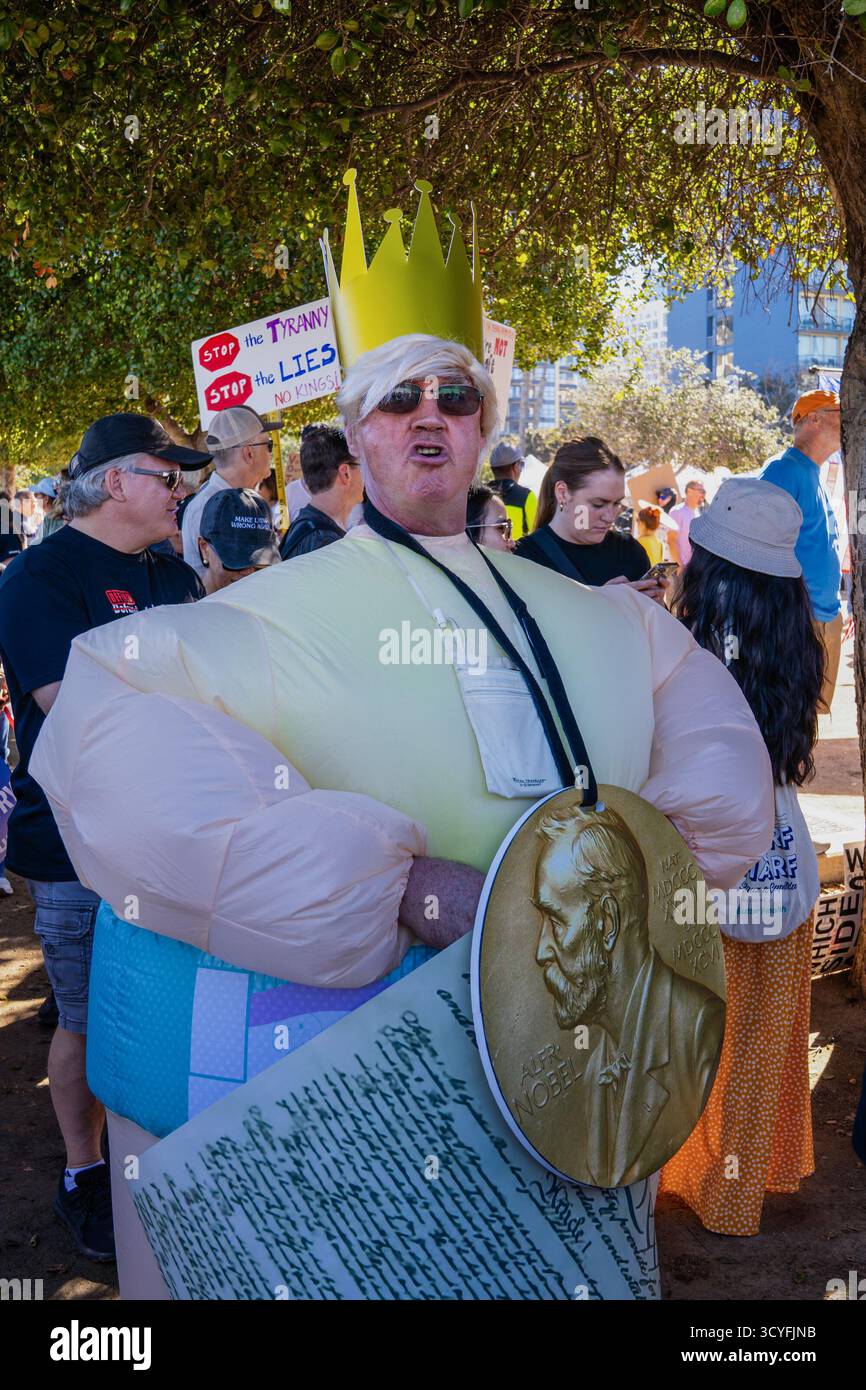 A protester dressed in an inflatable costume with a paper crown and ...