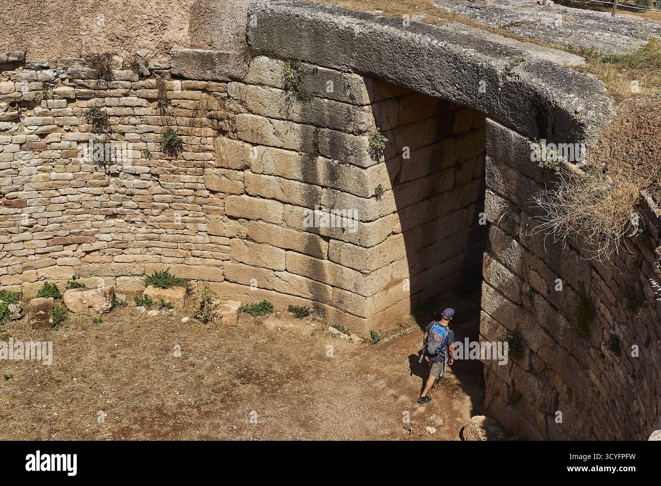Visitor walks through huge stone gate, Mycenaean domed tomb ...