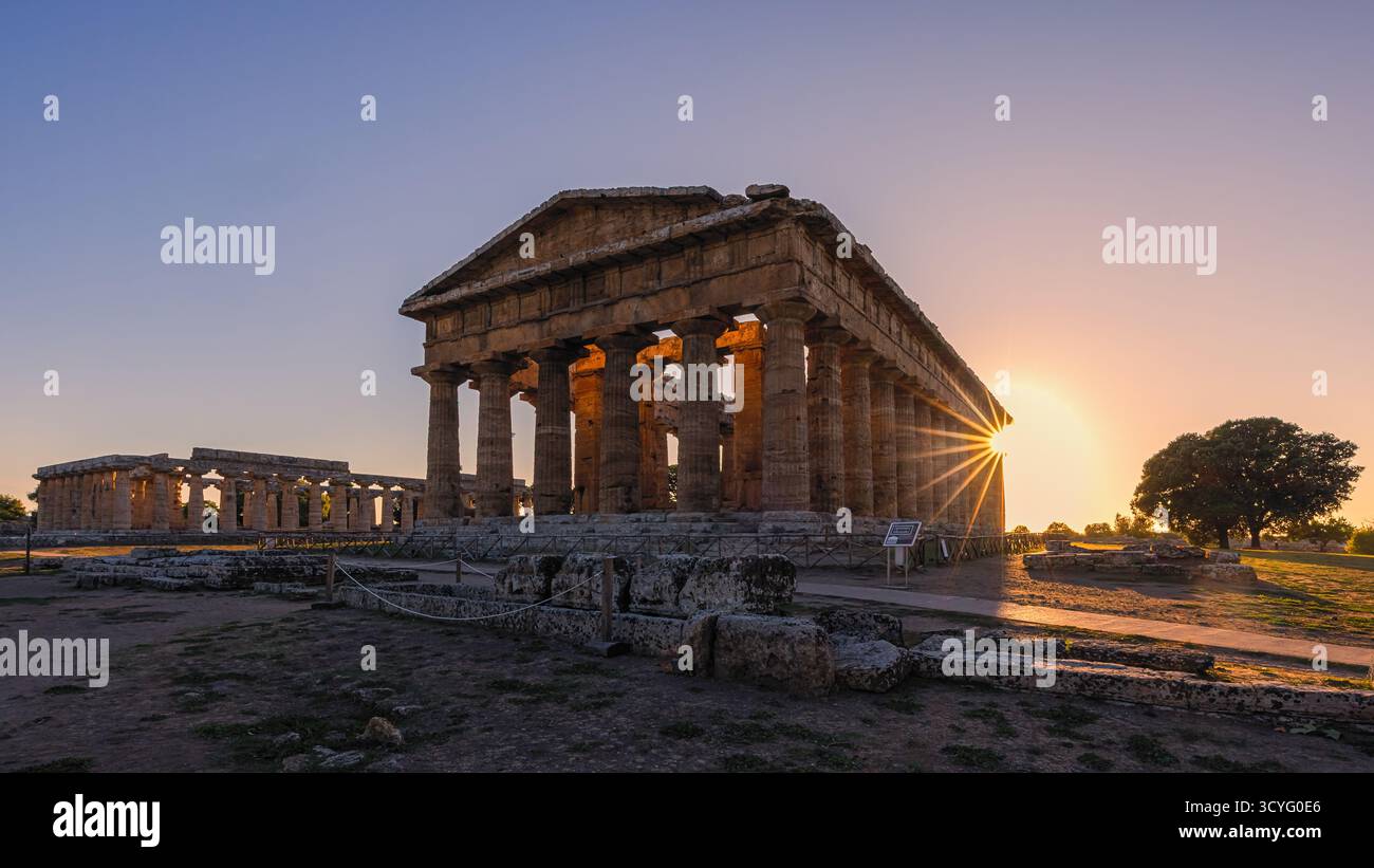 Golden evening light bathes the ancient Greek temples of Poseidon and ...