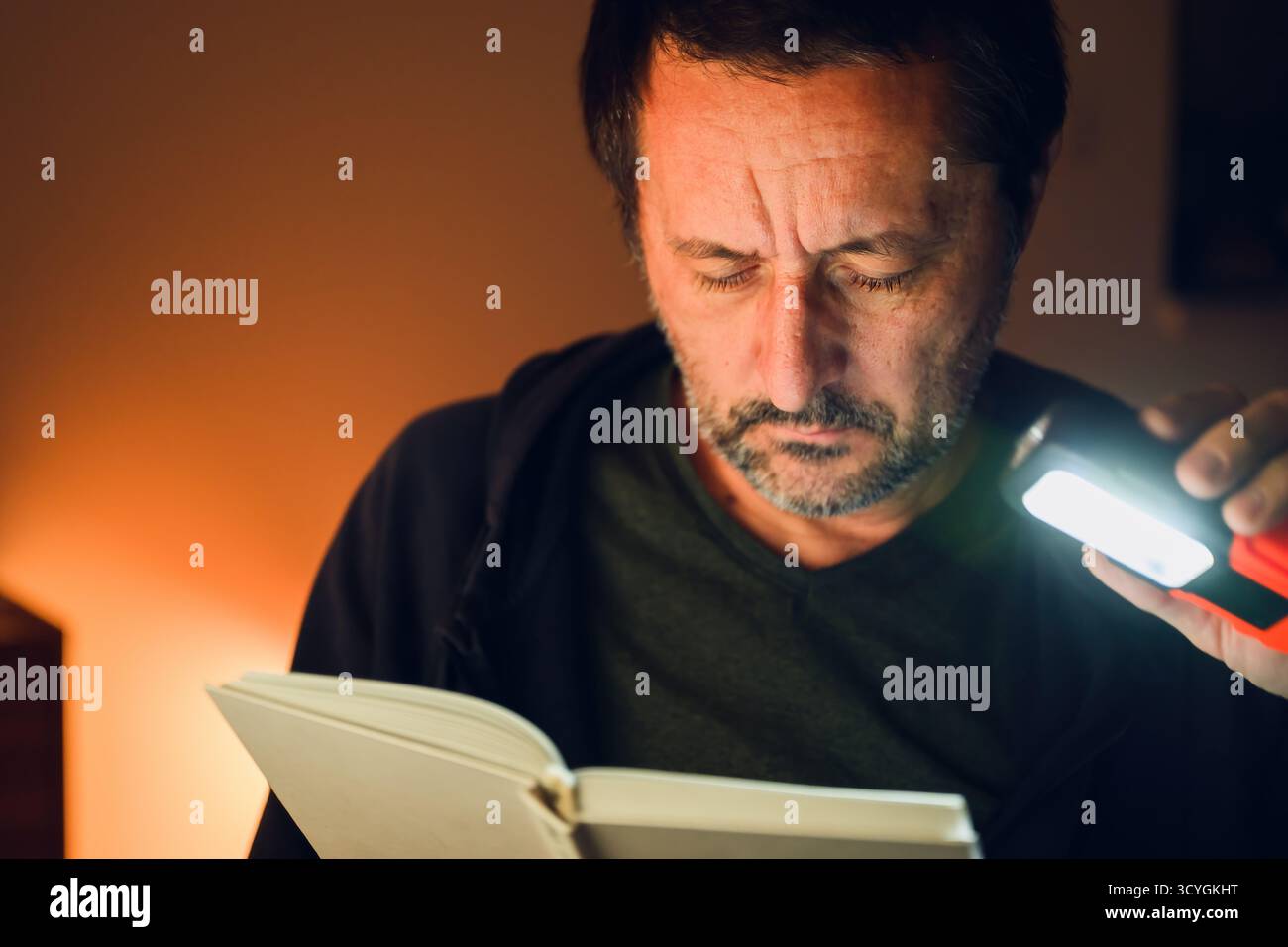 Man flashlight reading book hi-res stock photography and images - Alamy