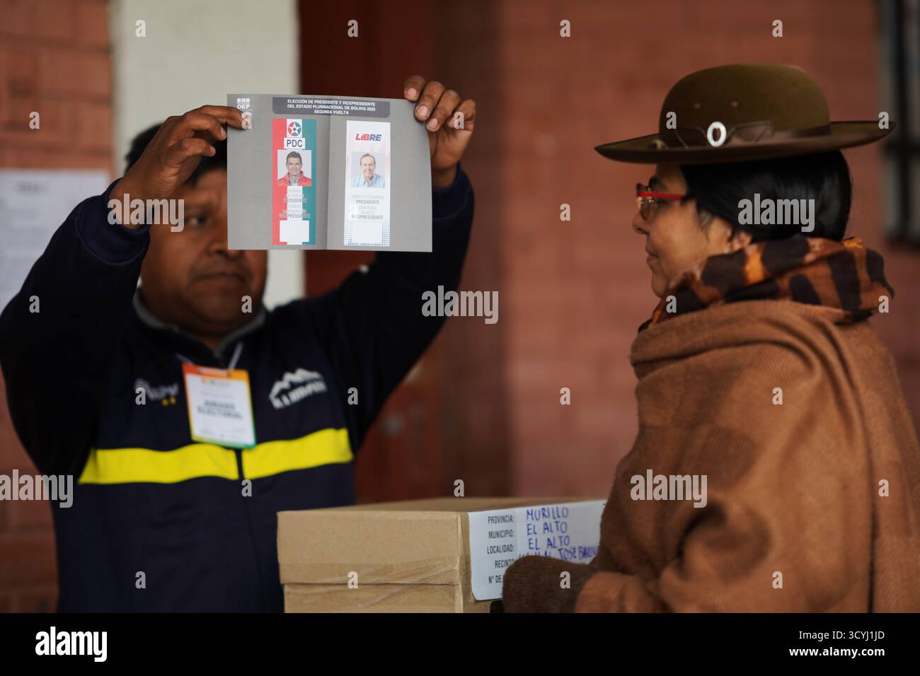 An electoral official shows an unmarked ballot with runoff candidates ...