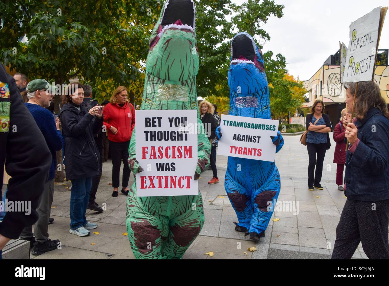 London, UK. 18th October 2025. Protesters wearing inflatable dinosaur ...