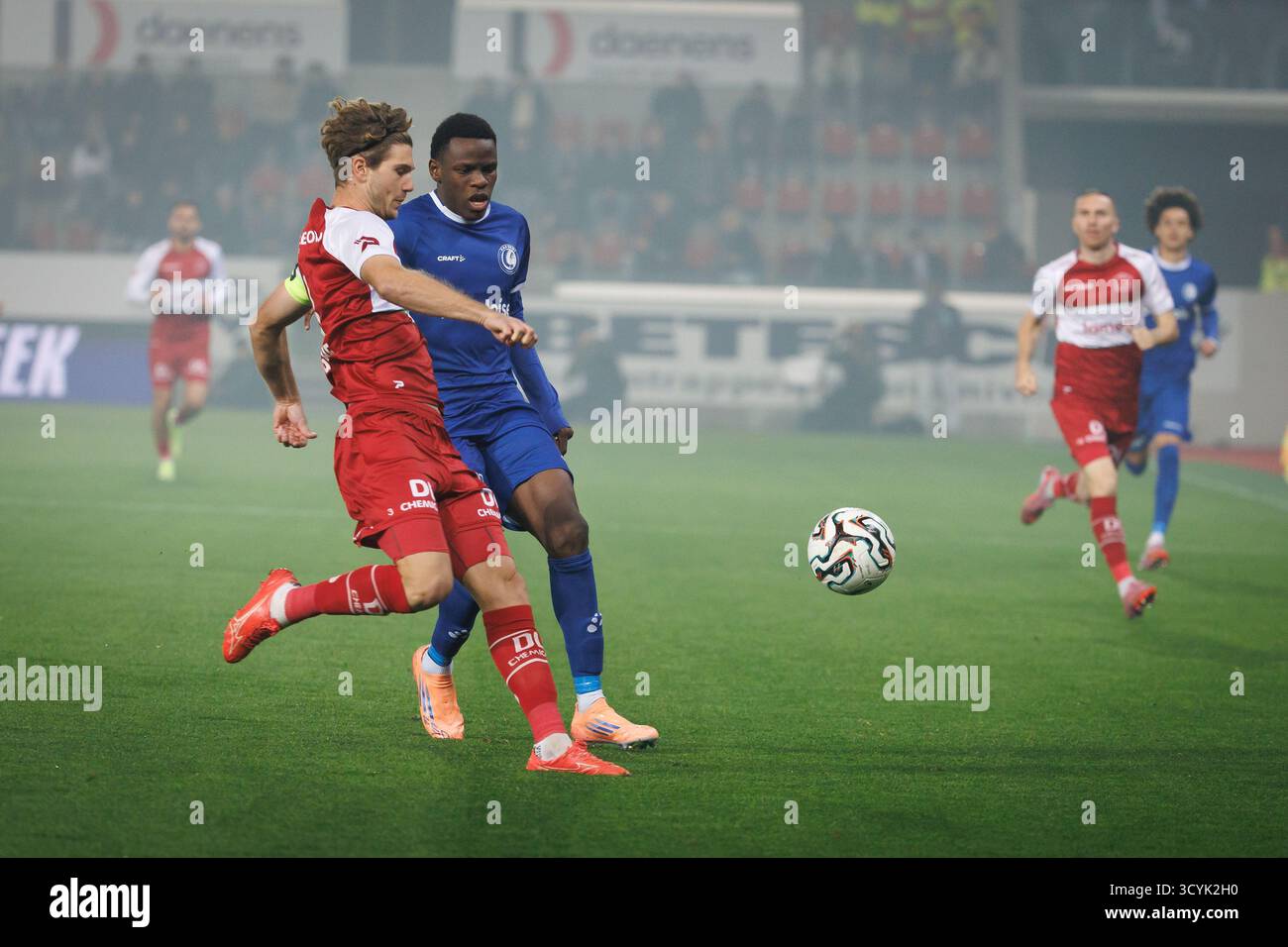 Waregem, Belgium. 19th Oct, 2025. Essevee's Anton Tanghe and Gent's ...