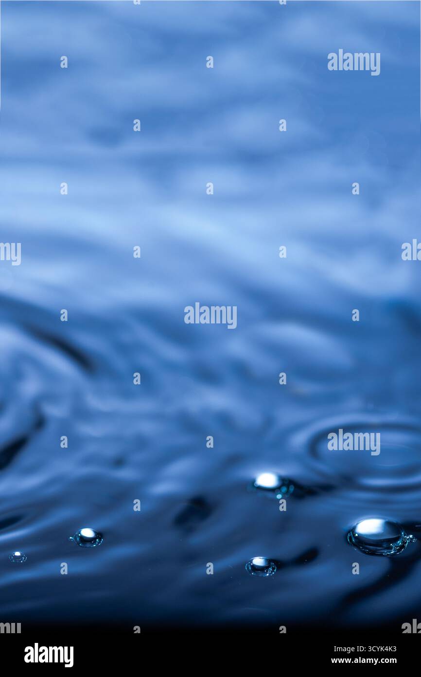 172.Close-up of water surface showing ripples and droplets. Blue tones ...