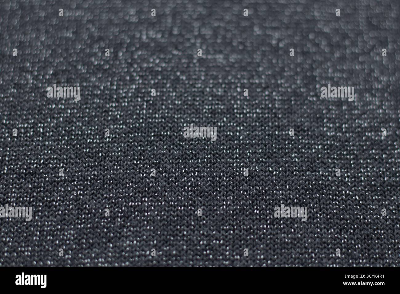 Close-up of dark textured fabric showing knit weave and subtle pattern ...