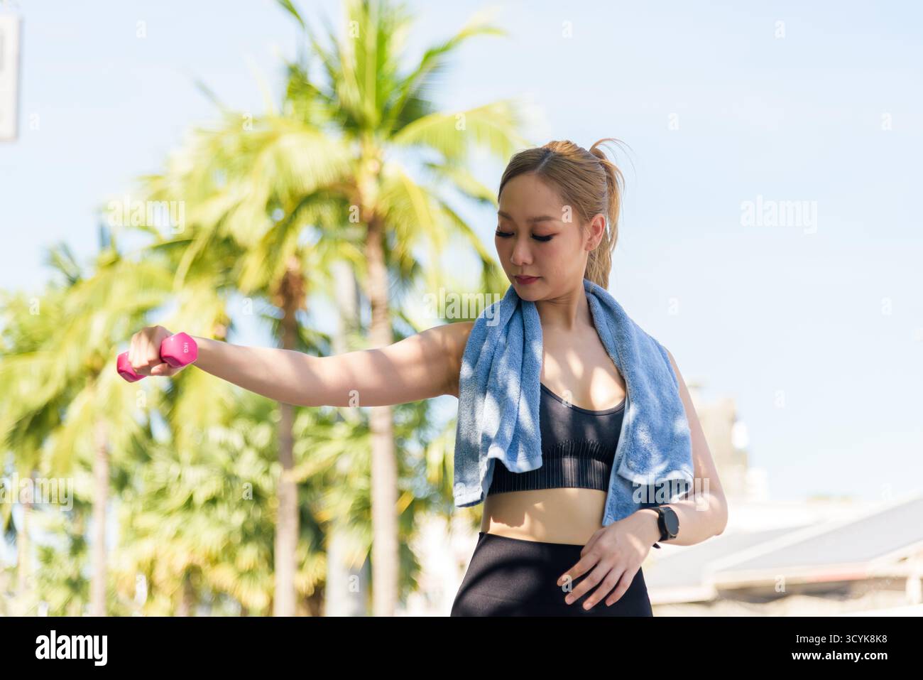 Sport fit woman performs intense outdoor exercise workout, lifting pink ...